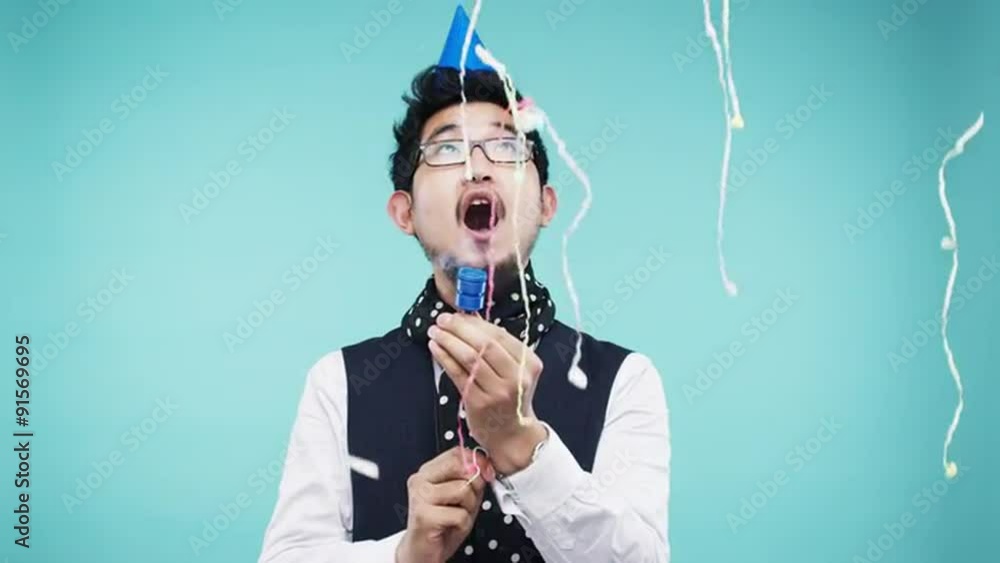 Crazy face Asian man pulling party popper slow motion photo booth blue ...