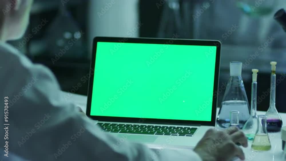 Scientist is using Laptop with Green Screen in Laboratory. Great for ...
