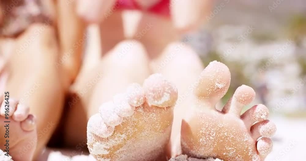 Close up of sandy feet wiggling toes three beautiful young woman ...