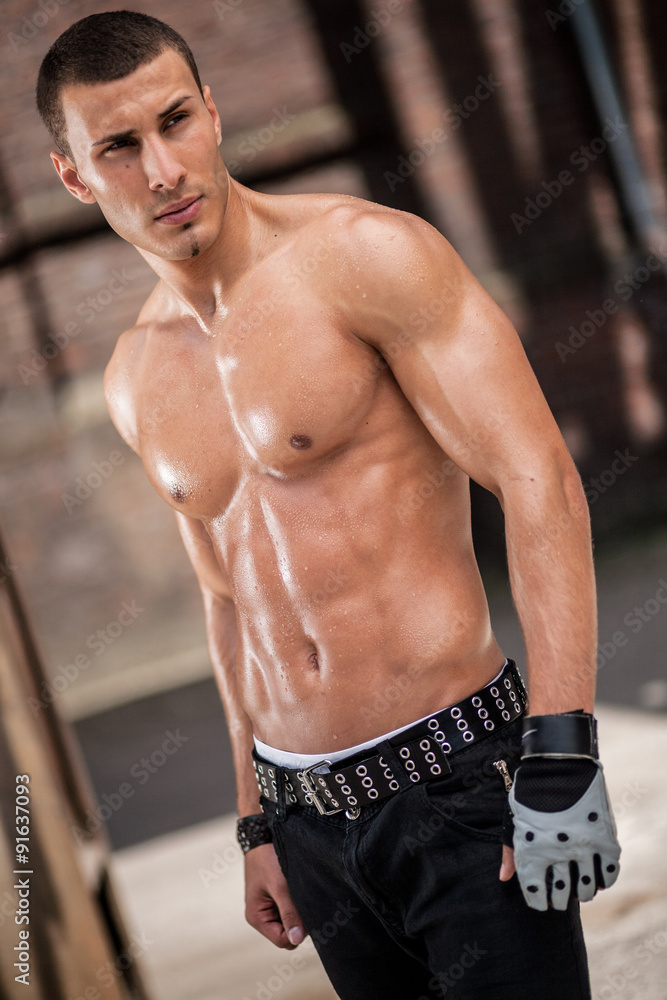 Junger Mann mit nacktem Oberkörper trainiert seinen Körper Stock Photo | Adobe Stock