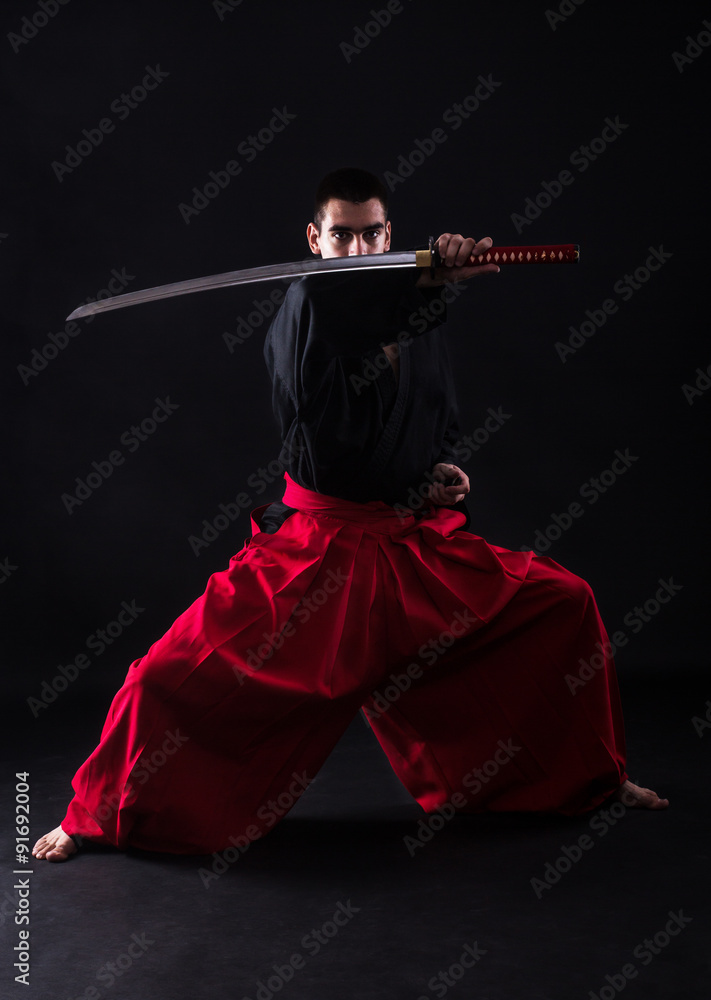 Young martial arts fighter with katana on black background Stock Photo ...