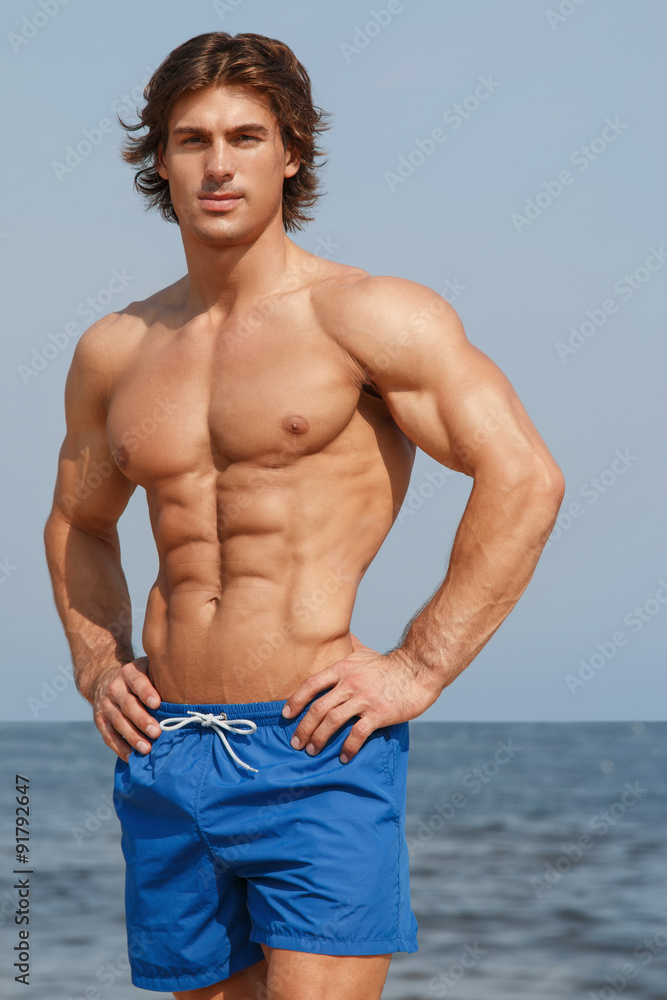 Muscular man on the beach Stock Photo | Adobe Stock