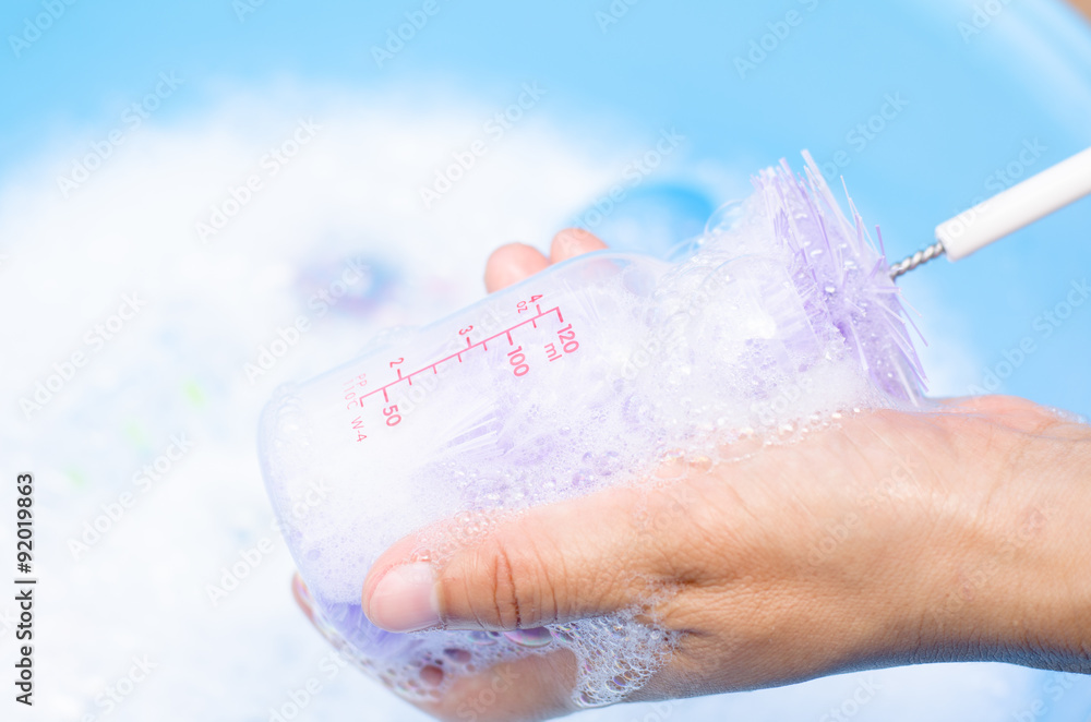 Mother hand washing baby milk bottle Stock Photo | Adobe Stock