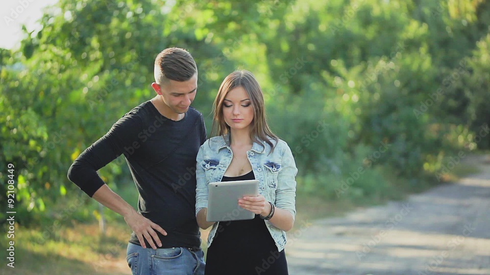 Vidéo Stock couple in love looking at the photos on the tablet / couple ...