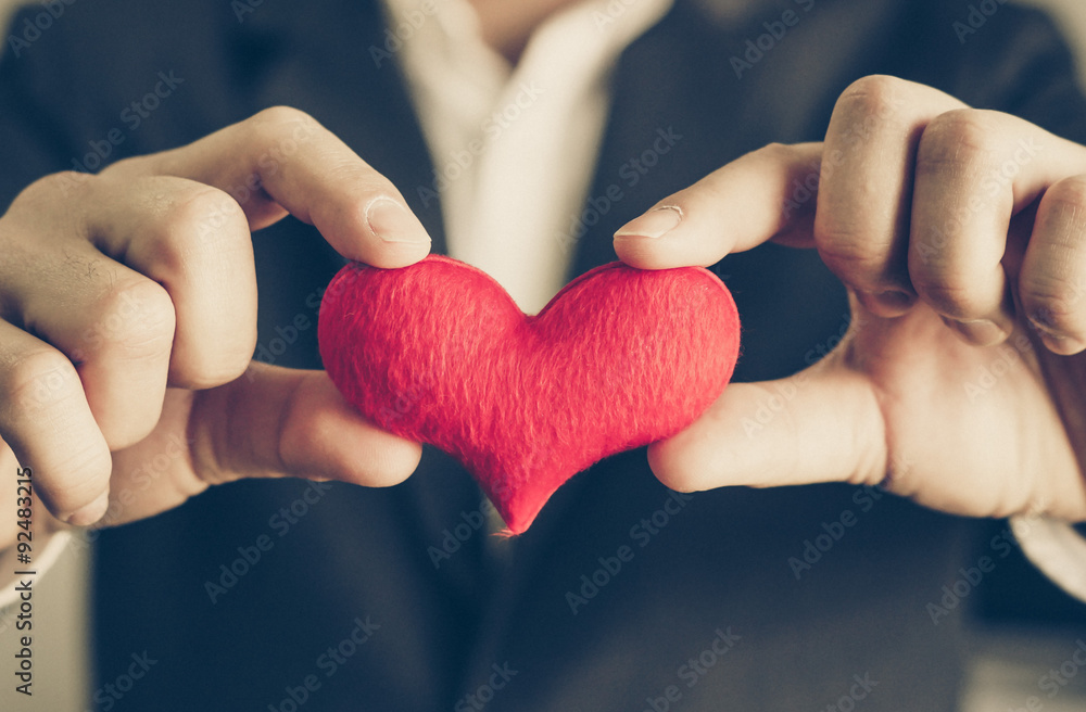 Businessman giving a red heart to a customer on isolated background ...