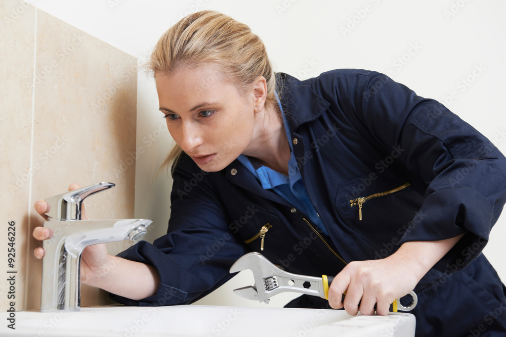 Female Plumber Working On Sink Using Wrench Stock Photo | Adobe Stock