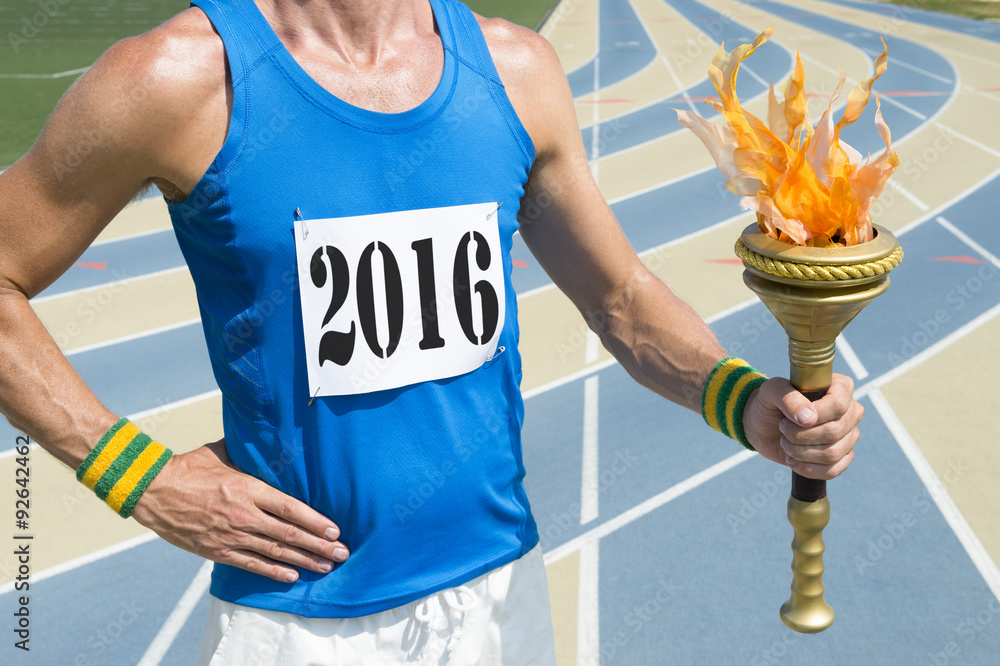 Athlete wearing 2016 race bib holding sport torch in front of running ...