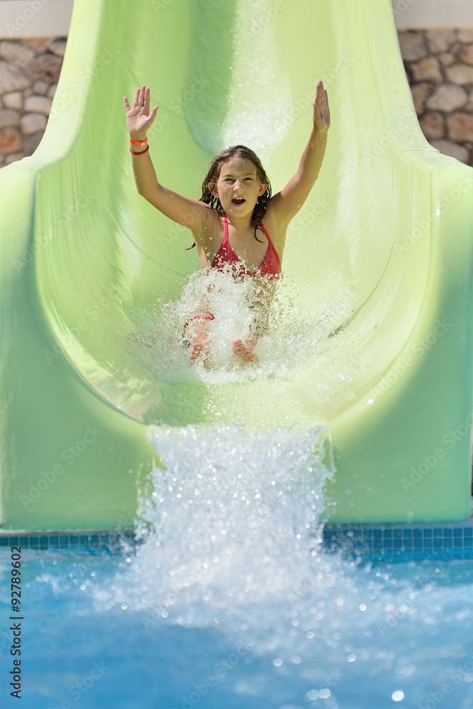 Girl rides on the water slide in a water park. Stock Photo | Adobe Stock