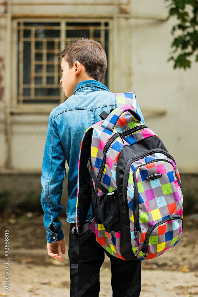 Niño va a la escuela con su mochila Stock Photo | Adobe Stock