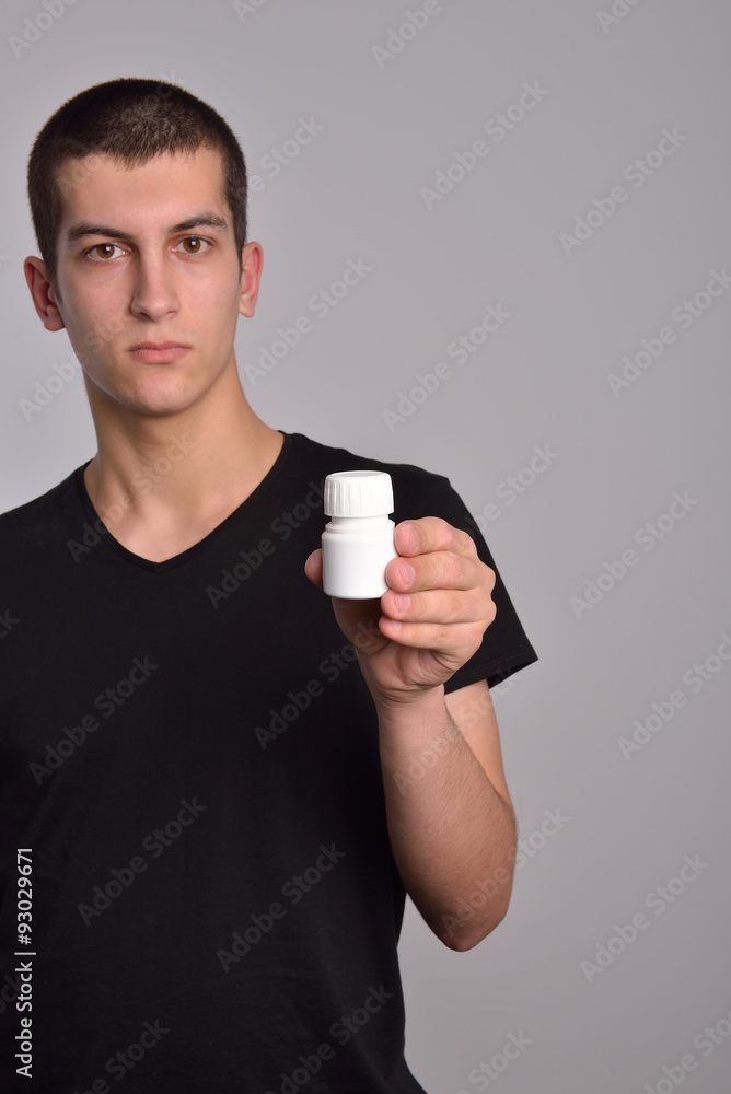 Young man holding a box of pills in his hand and shows the drugs foto ...