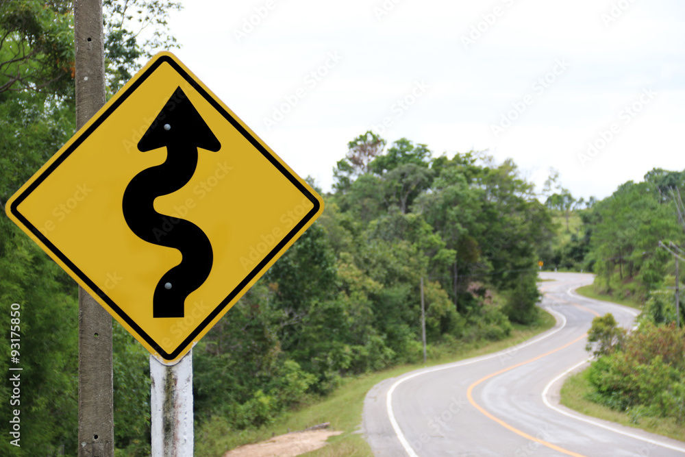 Winding road sign in the forest and mountain Stock Photo | Adobe Stock