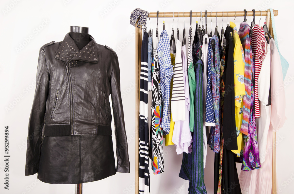 Dressing closet with colorful clothes arranged on hangers and an outfit ...