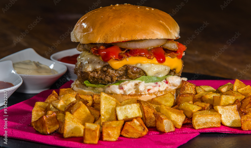 Big burger served for eating. Burger contains lots of extras cheese ...
