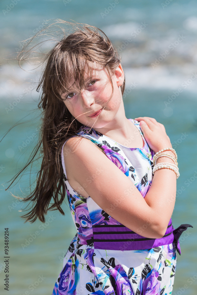 Cute preteen long hair girl on riverbank Stock Photo | Adobe Stock