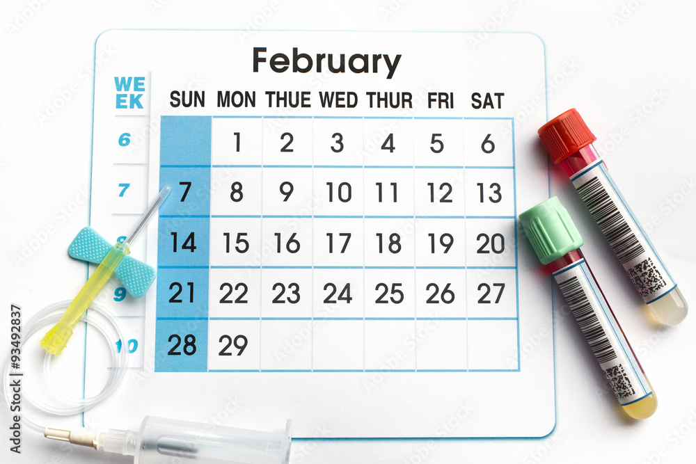 blood tubes and needle on the bottom of an appointment calendar of ...