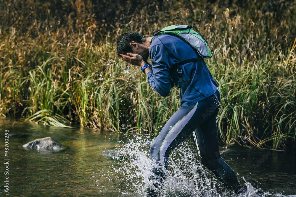 male athlete running across river. Rinses face with water Stock Photo ...