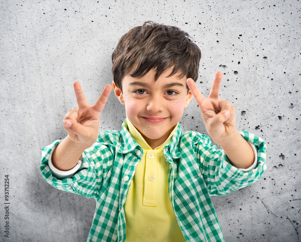 Boy making a victory sign over white background Stock Photo | Adobe Stock