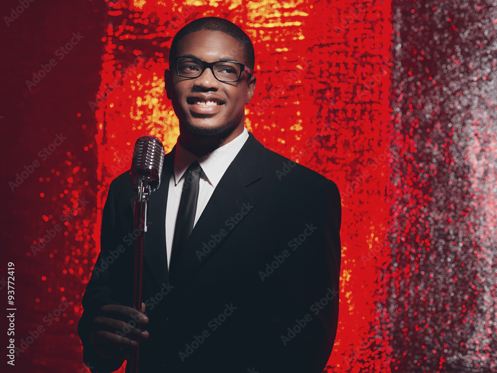 Retro 50s male hispanic singer in black suit and tie. Red reflec Stock ...