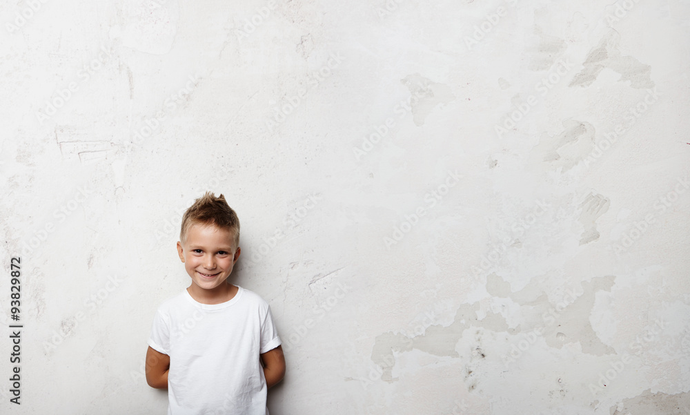 Little boy holds his hands behind back and smiling Stock Photo | Adobe ...