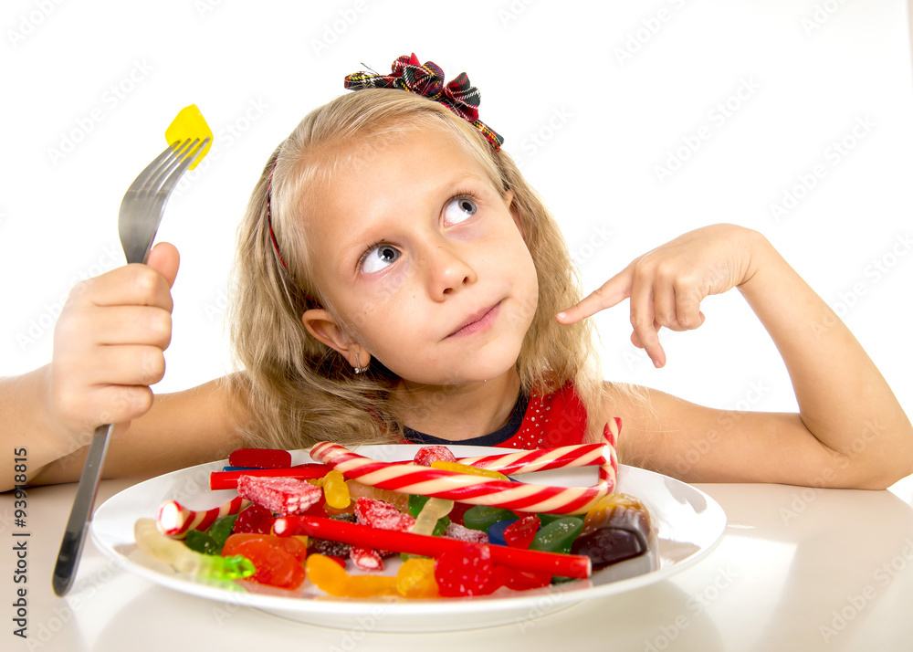 pretty happy Caucasian female child eating dish full of candy in sweet ...