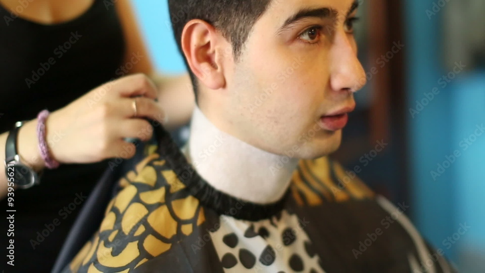 Barber prepares client for hairstyle. Stock Video | Adobe Stock