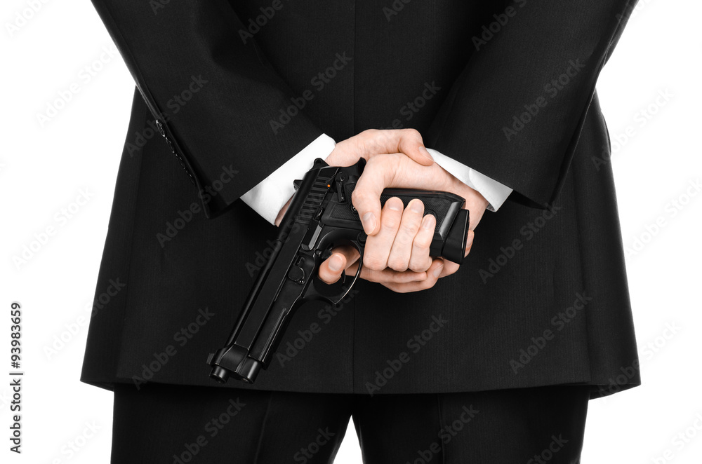 Firearms and security topic: a man in a black suit holding a gun on an ...