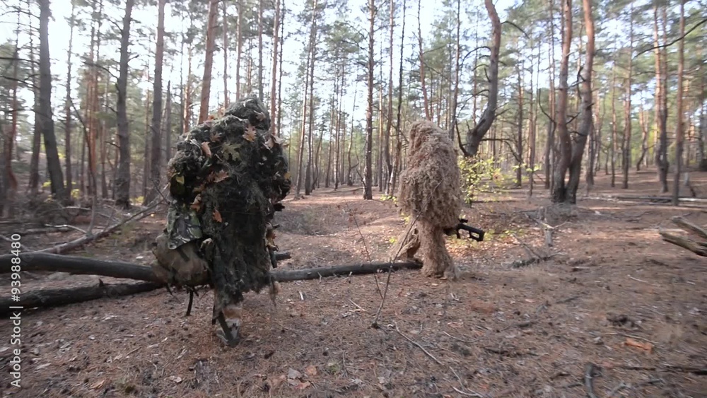 Two snipers go through the woods / Two sniper in camouflage suits going ...