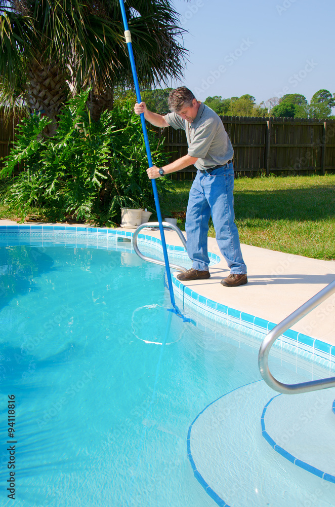 Residential pool cleaning service man working on a sparkling clean pool ...