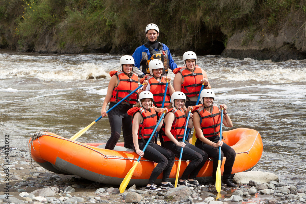 A young, adventurous team navigating through raging whitewater rapids ...