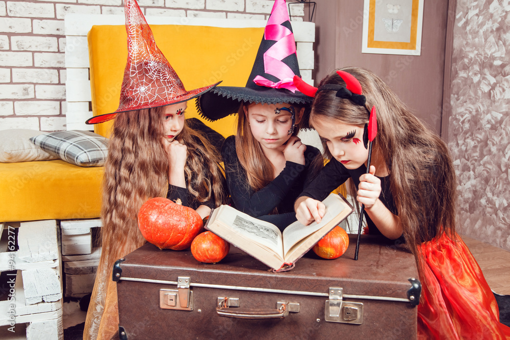 There are three little girls, who are dressed in costumes for Halloween ...