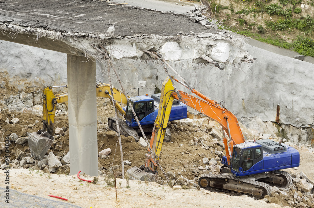 excavator demolition vehicle heavy equipment tearing down a bridge over ...