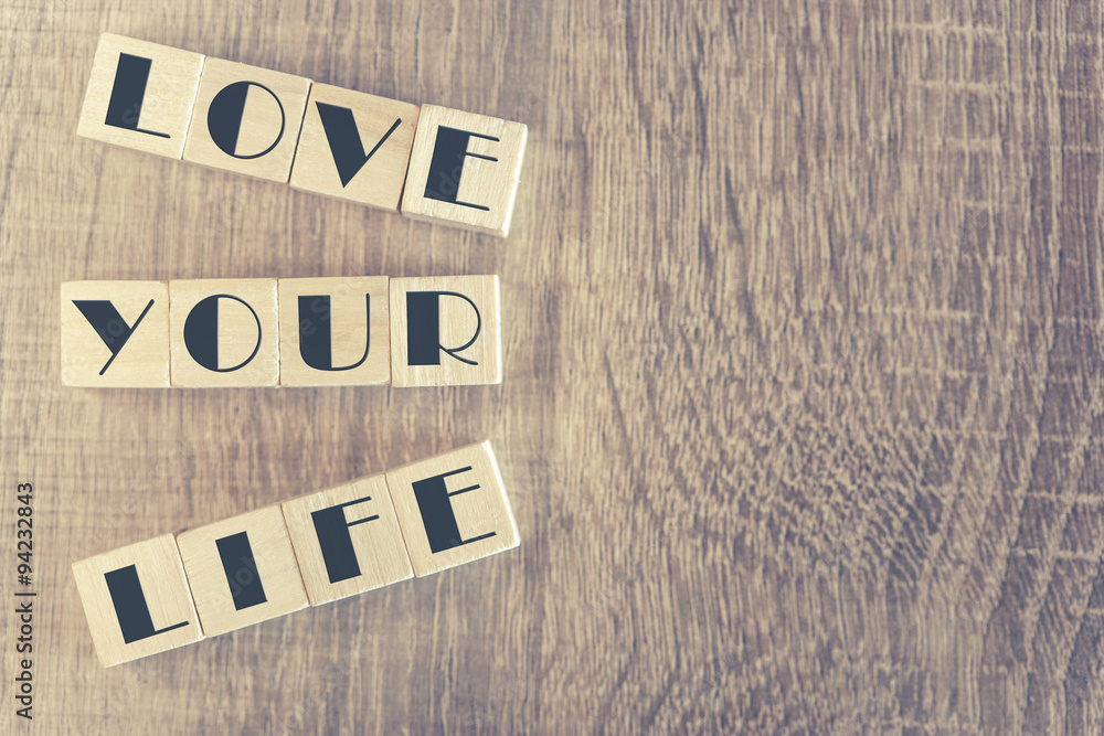 Wooden letter cubes forming Love Your Life message. Cross processed ...