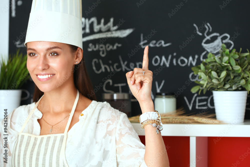 Chef woman portrait with uniform in the kitchen and pointing up Stock ...