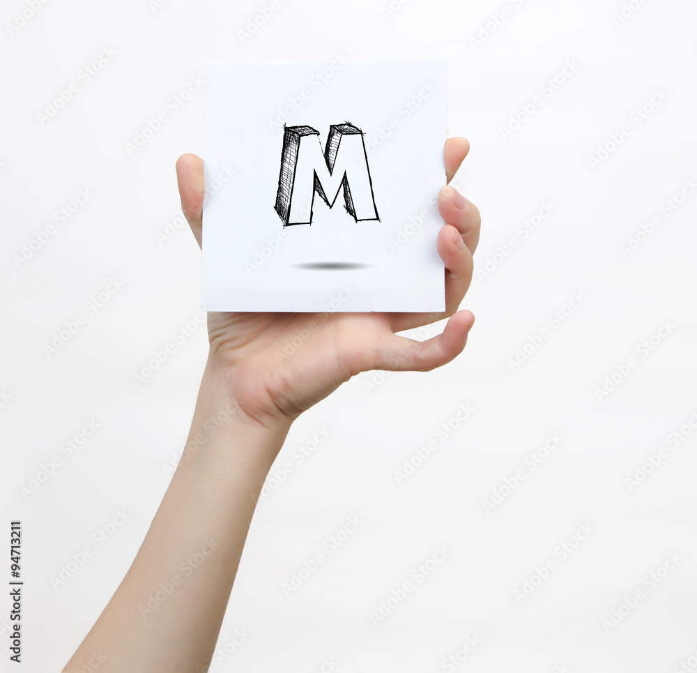 Hand holding a piece of paper with sketchy capital letter M, isolated ...