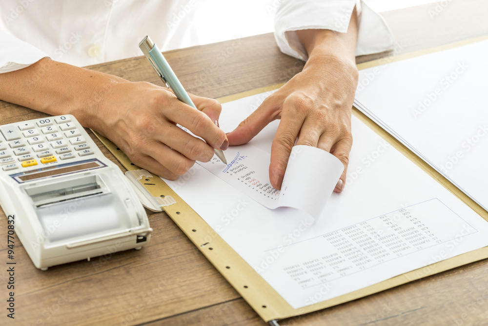Female accountant calculating and reviewing numbers on a receipt Stock ...