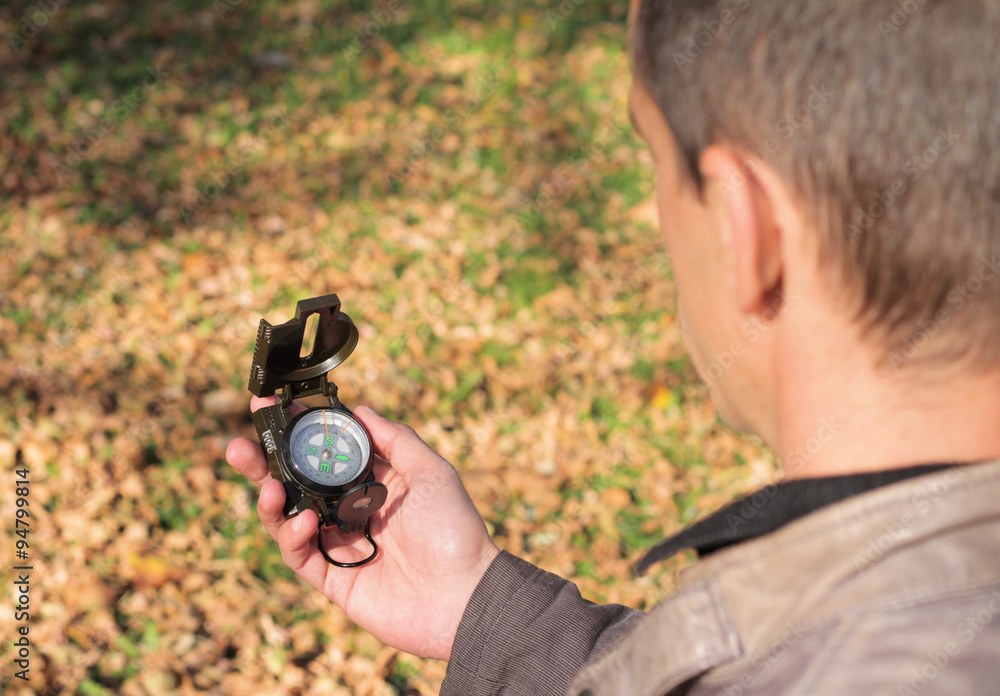 Man using compass in nature or autumn forest фотография Stock | Adobe Stock
