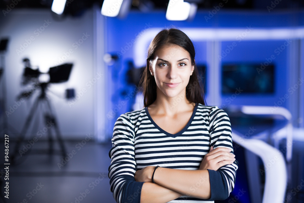 Young beautiful brunette television announcer at studio standing next ...