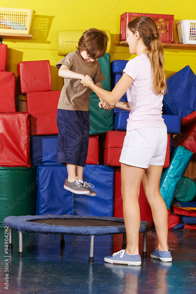 Junge springt auf Trampolin im Kindergarten Stock Photo | Adobe Stock