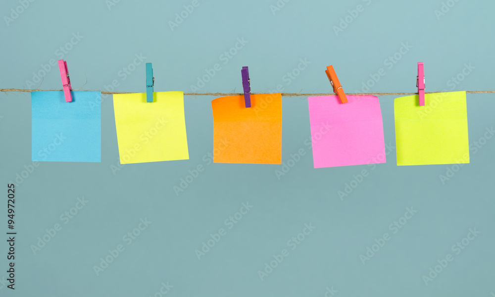 Empty colored paper notes hanging on a rope attached with pegs on a ...