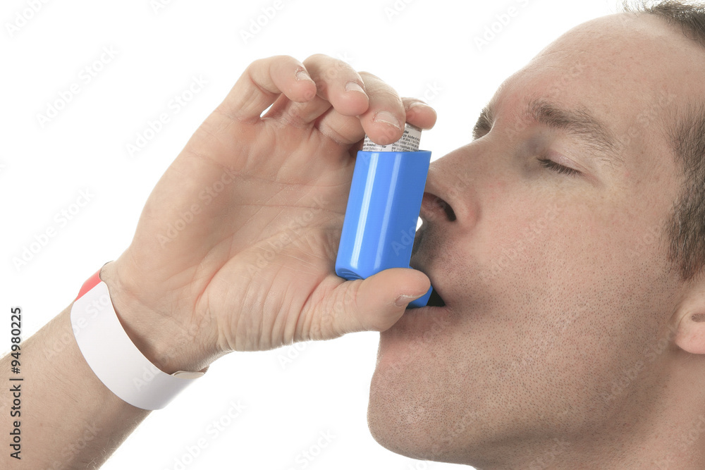 Young man using an asthma inhaler as prevention Stock Photo | Adobe Stock