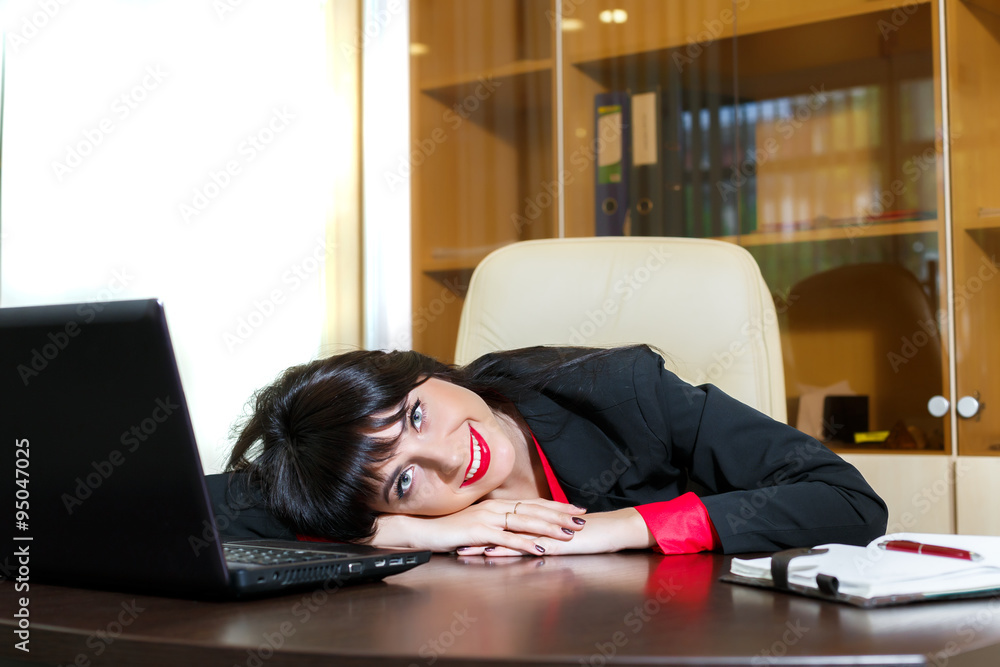 Smiling woman put her head on the desk in the office Stock Photo ...