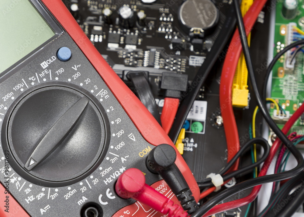 Red multimeter on motherboard background Stock Photo | Adobe Stock