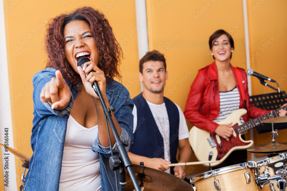 Female Singer Pointing While Performing In Recording Studio Stock Photo ...