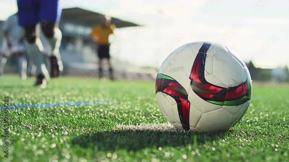 Close up of a soccer ball being kicked by a player in slow motion, with ...