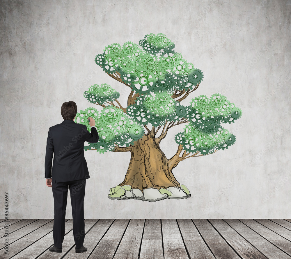 Rear view of a person in formal suit who is drawing a tree on the ...