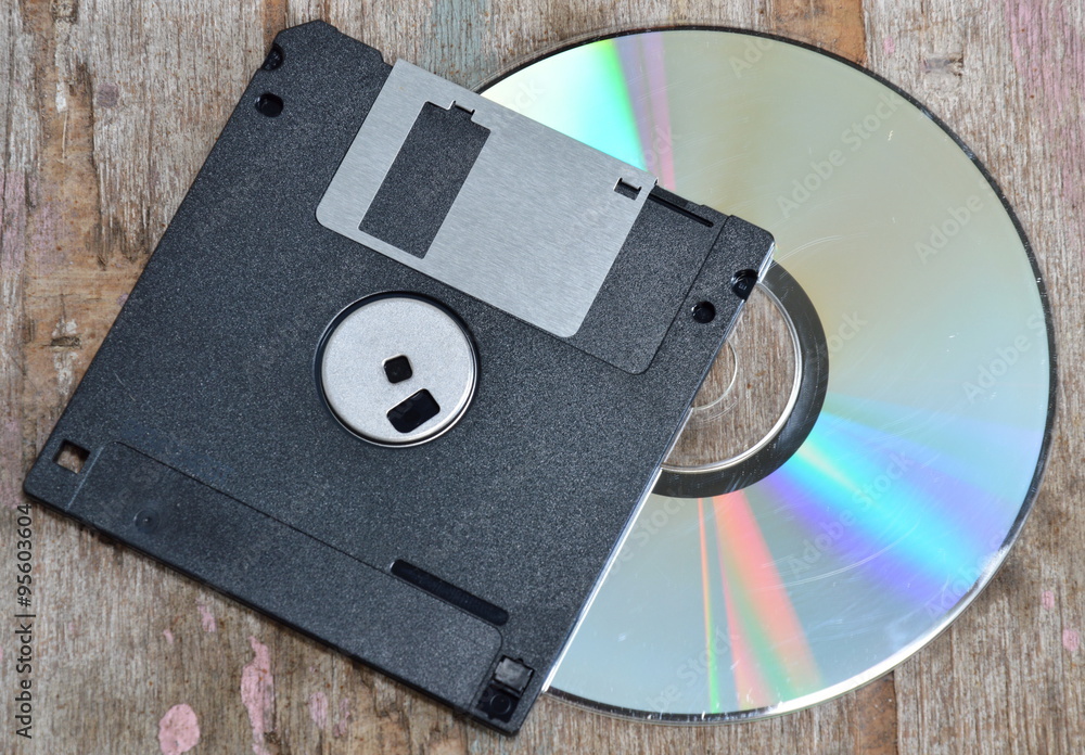 diskette and compact disc on wood board foto de Stock | Adobe Stock