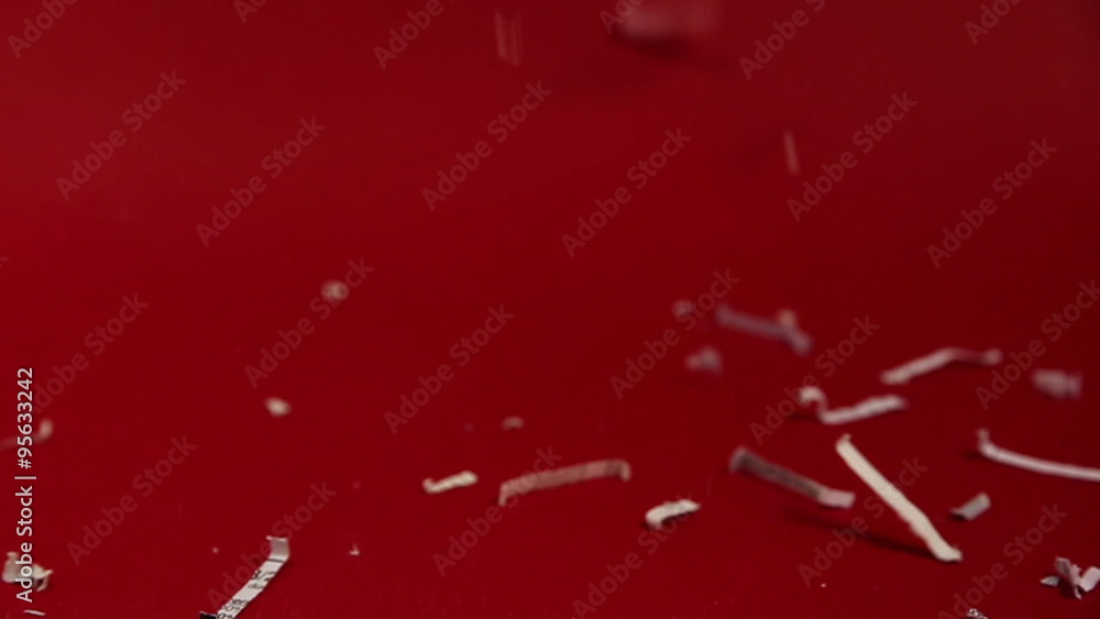 Shredded Paper Falling Slow. pieces of shredded paper fall on a red ...