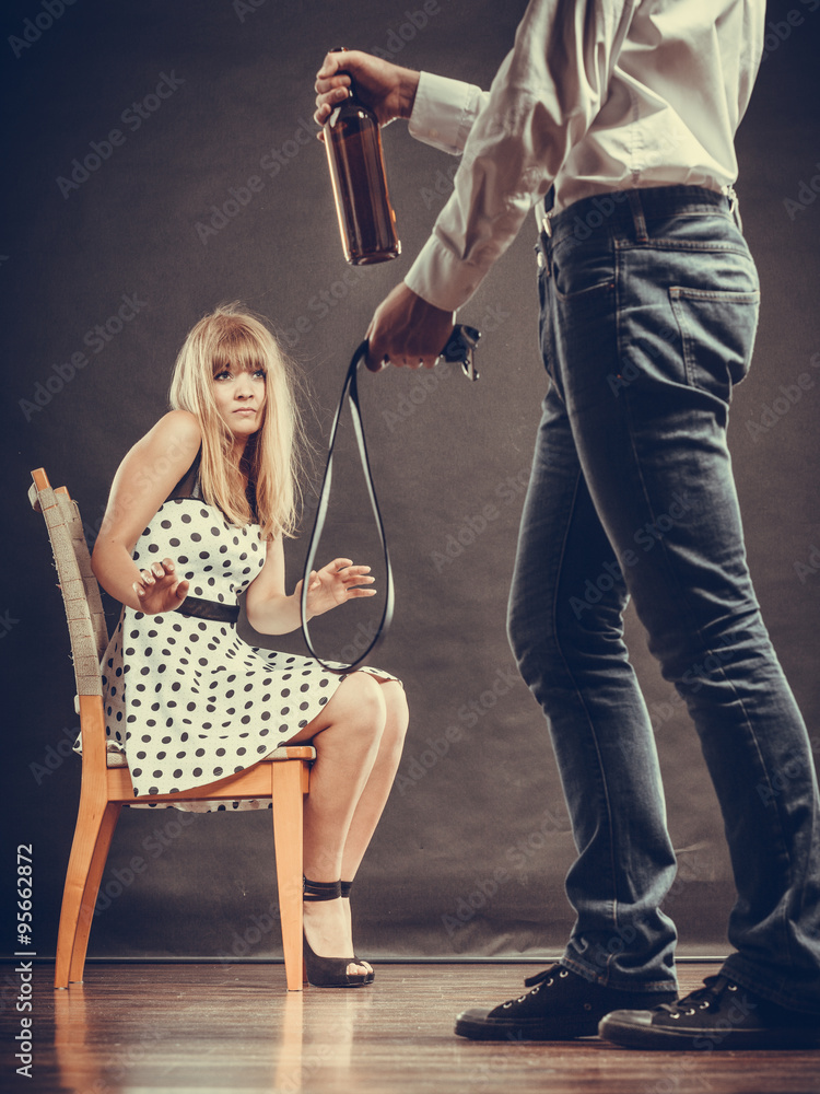Man alcoholic beating his scared woman with belt Stock Photo | Adobe Stock