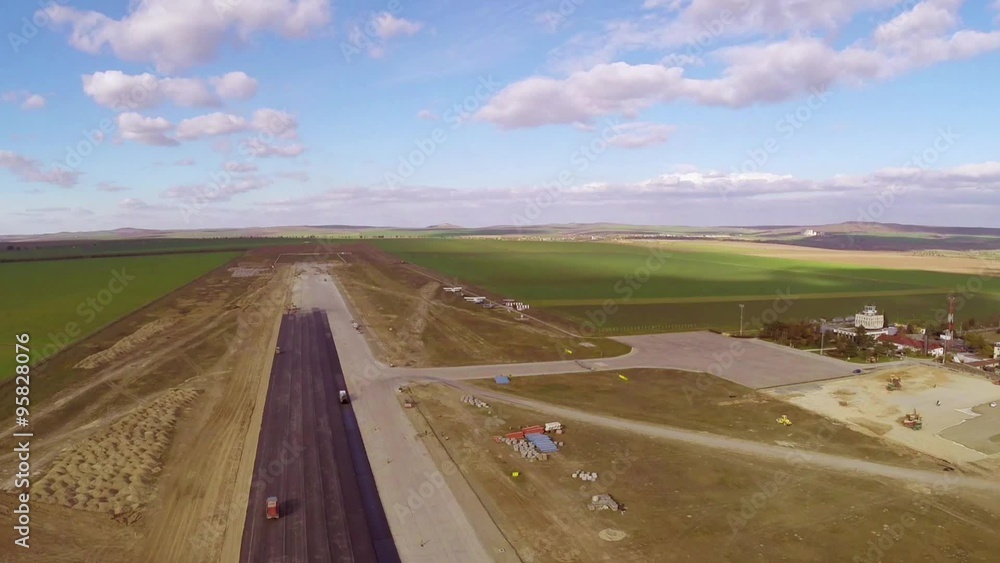 Tracked paver laying fresh asphalt pavement on an airport runway ...