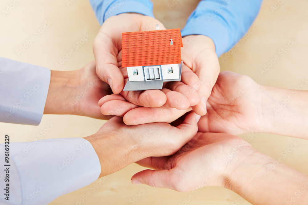 Viele Hände halten ein kleines Haus Stock-Foto | Adobe Stock